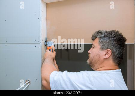 Using multi tool worker cuts drywall plasterboard with cutting blade ...