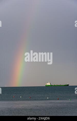 Rainbow and container ship Stock Photo - Alamy