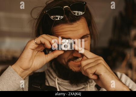 Young woman photographing with tiny vintage camera Stock Photo - Alamy