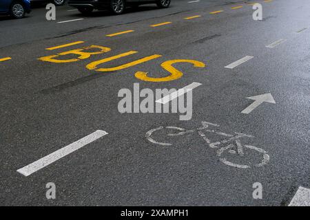 A paved city street with yellow markings designating a bus lane and ...