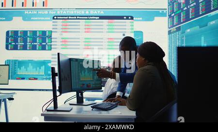 Financial analyst works on resource allocation plans with his staff ...