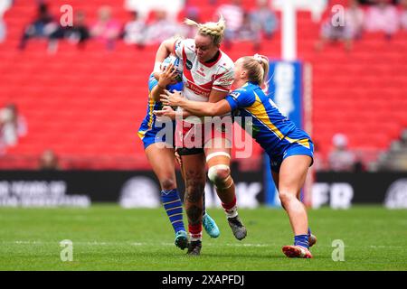 St Helens' Naomi Williams (centre) is tackled by Leeds Rhinos' Keara ...