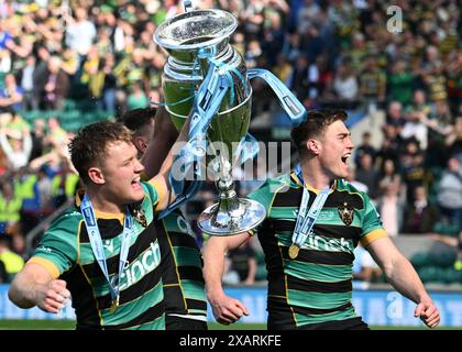 Northampton Saints players celebrate with the trophy on the pitch after ...