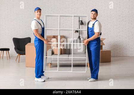 Loaders carrying shelving unit at home on moving day Stock Photo - Alamy