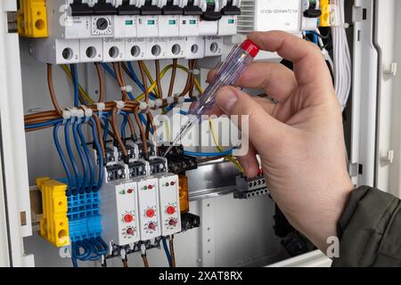 Technician using a voltage tester on a solar field's electrical ...