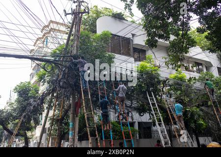 Workers repairing overhead internet cables damaged by a storm in Dhaka ...