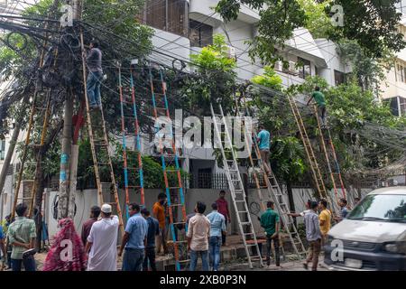 Workers repairing overhead internet cables damaged by a storm in Dhaka ...