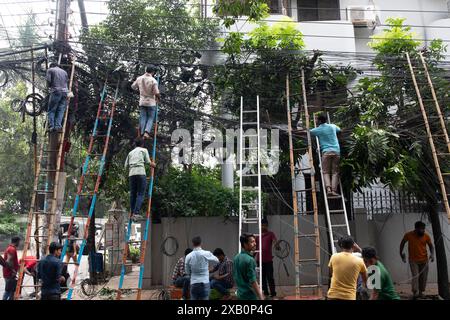 Workers repairing overhead internet cables damaged by a storm in Dhaka ...