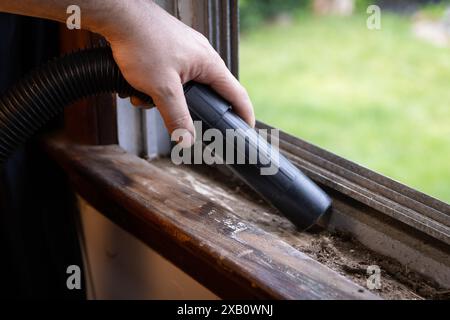 Cleaning debris out of window ledge and grooves with vacuum Stock Photo ...