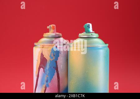 Spray paint cans on red background Stock Photo - Alamy