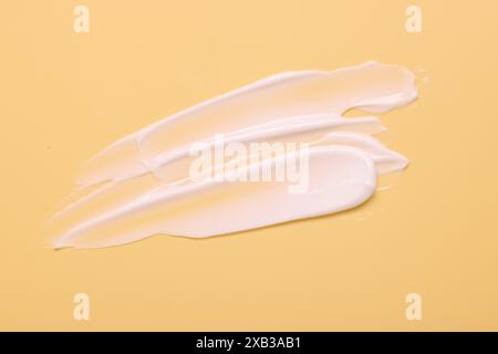 Samples of face cream on pale yellow background, top view Stock Photo ...