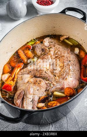 Braised lamb mutton shoulder in a baking dish with vegetables in red ...