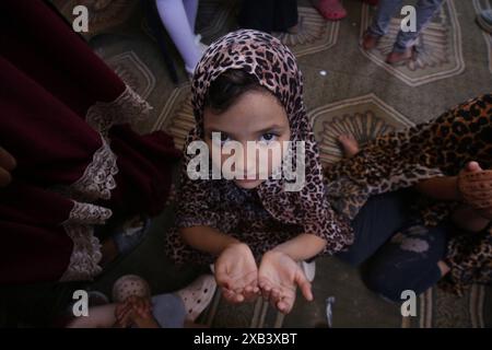 Displaced Palestinian children gather around a makeshift cube ...