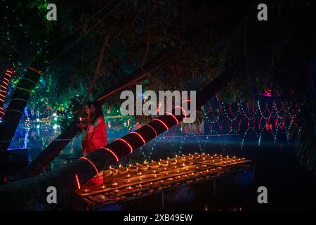 Young women illuminate Diwali lamps at the pond of Sri Sri Baradeswari ...