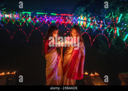 Young women illuminate Diwali lamps at the pond of Sri Sri Baradeswari ...