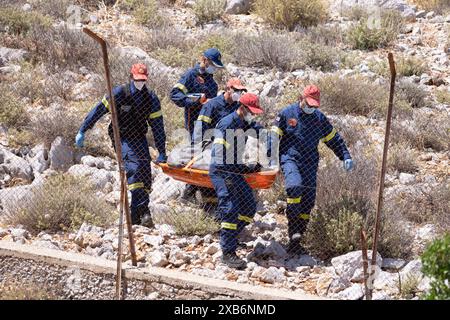 Greek Fire Services officers carrying away on a stretcher the body of ...