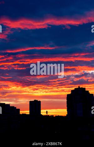 Fantastic pink sunset against bright blue sky with fluffy white clouds ...