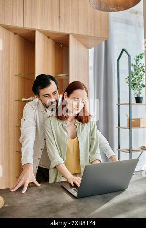 redhead and bearded man working on laptop near son on blurred ...