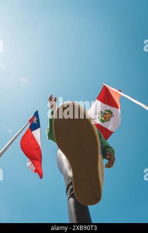A woman walking at the border, the flags of Peru and Chile. Migration ...