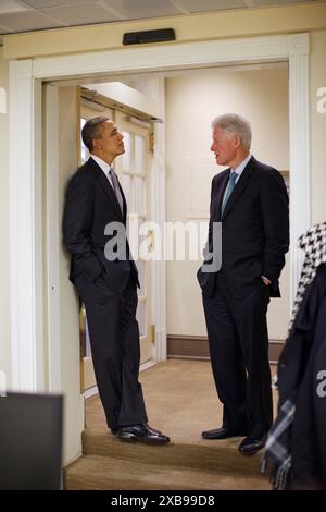 President Barack Obama and former President Bill Clinton listen as ...