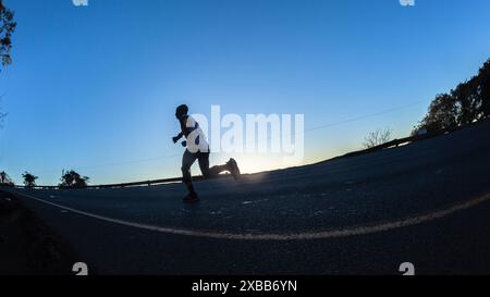 Marathon runners silhouetted morning dawn sunrise running up hill in ...
