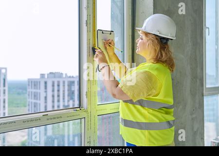 Female window decorator designer measuring window with tape measure ...