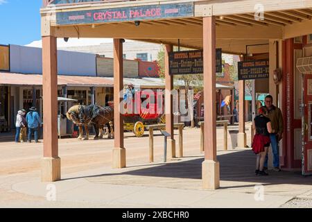 Horse drawn stagecoach on dirt road lined with territorial style old ...