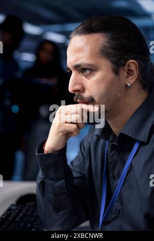 Admin in data center facility managing call center tasks, speaking into ...