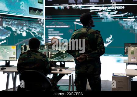 Diverse army officers examining real time data on a hologram, working ...