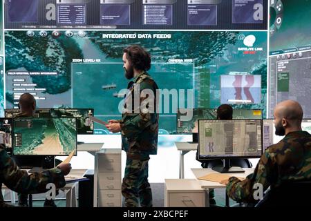 Diverse army officers examining real time data on a hologram, working ...