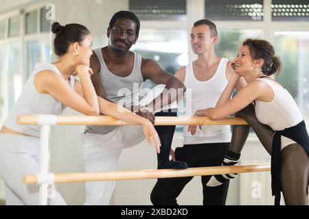 Group of dancers talking at ballet barre Stock Photo - Alamy