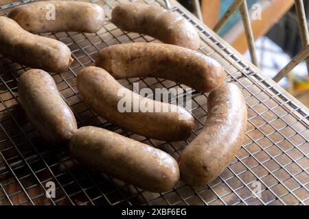 putting cured sausage link on cooling rack to dry the natural casing ...