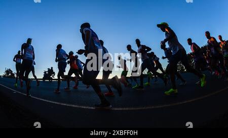 Marathon runners silhouetted morning dawn sunrise running up hill in ...