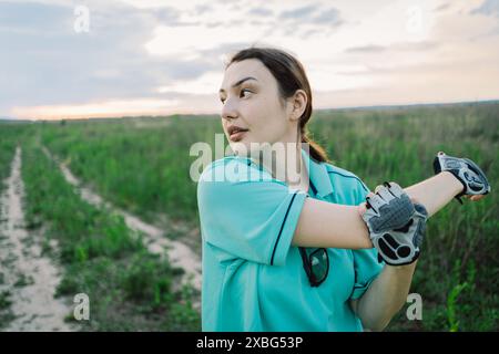 Woman Stretching Before Bike Ride in Green Field Stock Photo - Alamy