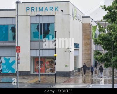 Primark shop on a rainy day in Corby town centre shopping complex and ...