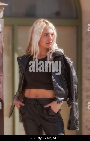 A woman in leather clothes stands in an autumn park Stock Photo - Alamy