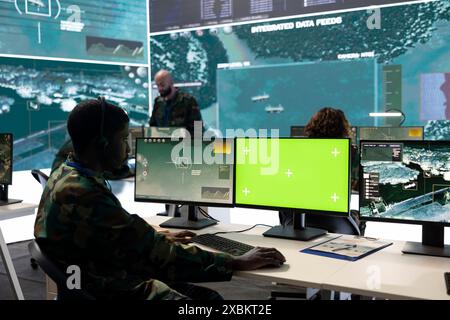 Army personnel monitoring surveillance imagery from satellite system on ...
