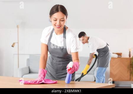 Female Asian janitor cleaning table in office Stock Photo - Alamy