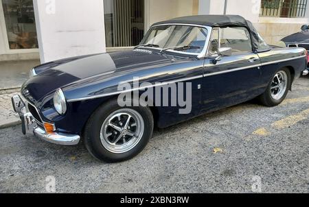 Dark blue 1970-s MG MGB roadster parked by the curbside, back left ...