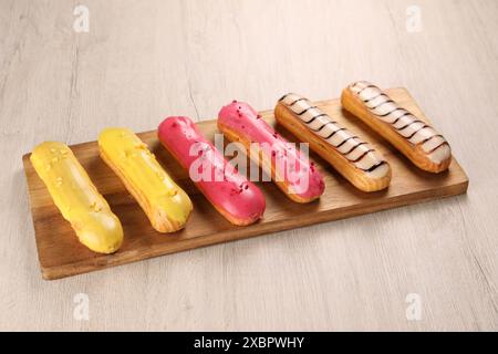 Light wooden board with sweet eclairs, closeup Stock Photo - Alamy