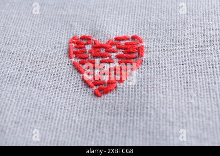 Embroidered red heart on gray cloth, top view. Space for text Stock ...