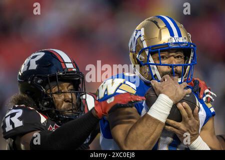 Winnipeg Blue Bombers' Nic Demski (10) leaps over Saskatchewan Roughriders' Kosi Onyeka (31) for ...