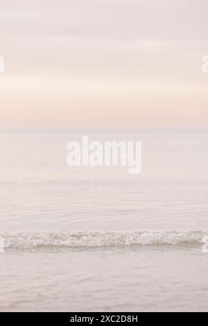 Waves approaching beach sand during golden sunset Stock Photo - Alamy
