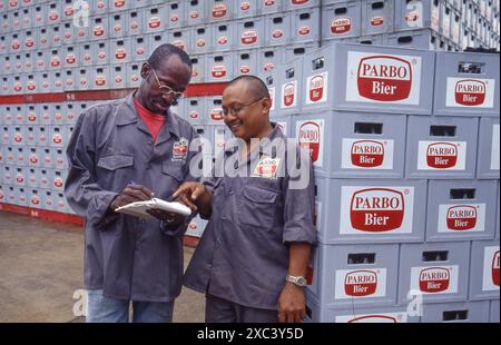 Suriname, Paramaribo - Factory workers discuss the storage of the ...
