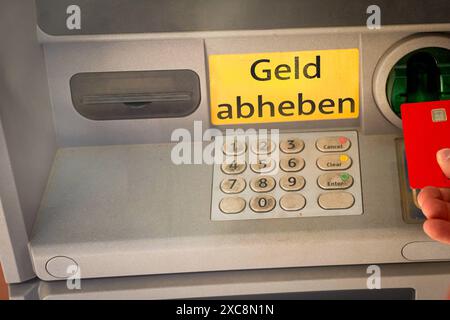 13 June 2024: An ATM with the inscription: Fees Notice. A man inserts ...