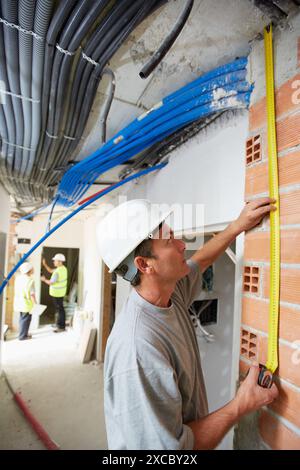 Worker with protective equipment, PPE, Taking retractable tape measures ...