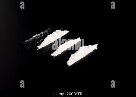 Cocaine powder in three lines isolated on black background ...