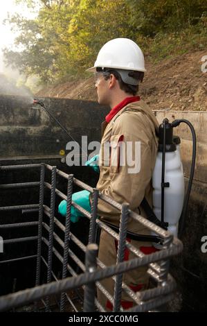 Applying form release agents with sprayer, concrete formworks, housing ...