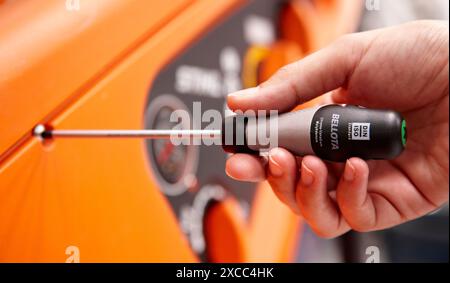 Worker using screwdriver in car repair shop Stock Photo - Alamy