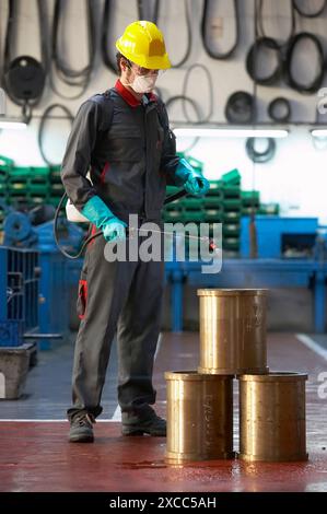 Industrial spray cleaning, degreasing bronze sleeves Stock Photo - Alamy